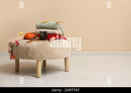 Warm sweaters on pouf near color wall Stock Photo - Alamy