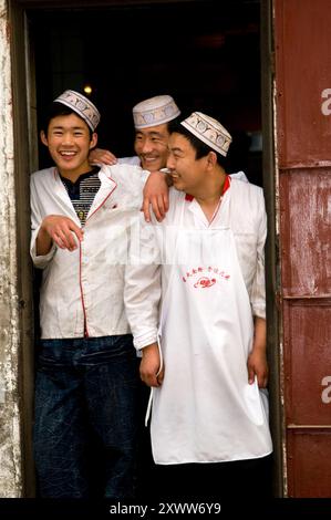 A group of Chinese muslim cooks enjoy a laugh at the door of the ...