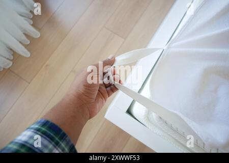 Placing the white sheet on the mattress for added comfort Stock Photo ...