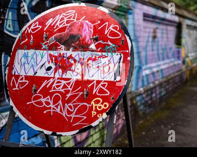 Graffiti on a no entry road traffic sign with love hearts and policeman ...