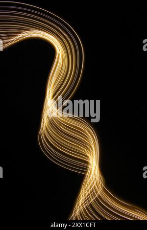Long exposure photograph of neon gold colour in an abstract wavy ...
