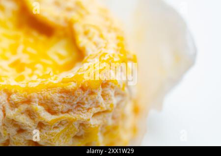 A yellow cheese is sitting in a paper wrapper, popular soft french ...