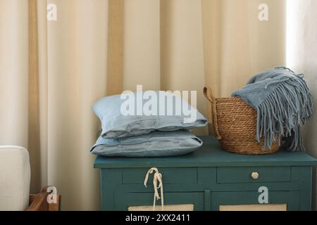 Pillows and wooden chest of drawers in room Stock Photo - Alamy