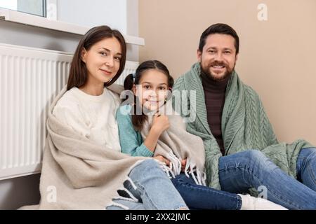 Happy family near heating radiator at home Stock Photo - Alamy