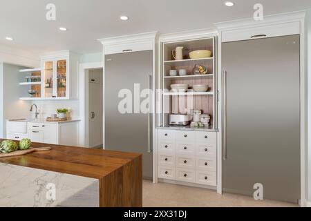 Corner of kitchen with Sub-Zero column fridge and freezer and small bar ...