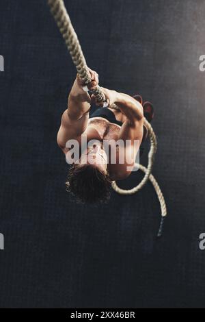 Man, bodybuilder and rope for training at gym for bodybuilding with ...