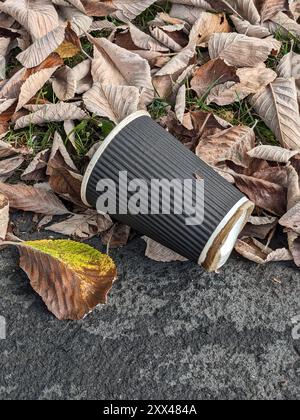 A discarded Coffee Cup and Lid with Liquid Waste Litter on Pavement ...