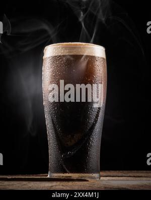 Glass of dark beer over a dark textured wooden background Stock Photo ...