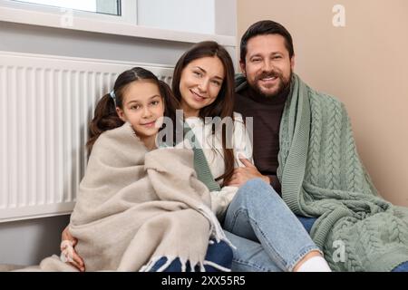 Happy family near heating radiator at home Stock Photo - Alamy