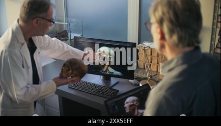 Two archaeologists study fossil skull, create 3D model of prehistoric ...