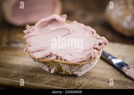 Roll with Liverwurst (German cuisine) on an old wooden table as ...