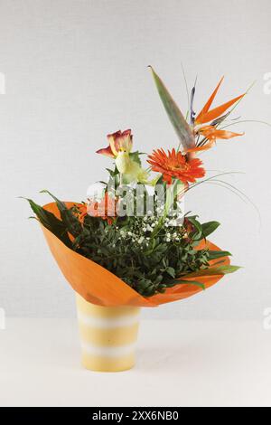 Floral arrangement with orchids, roses and carnations on wooden ...
