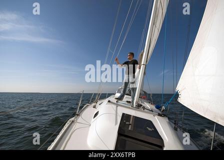 Skipper stands on the deck of his sailing yacht Stock Photo - Alamy