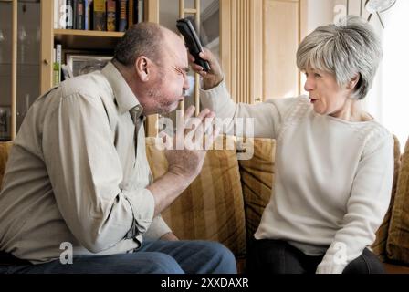 Married couple fight over the remote control Stock Photo - Alamy
