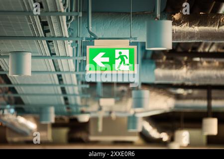 Emergency exit sign. Office spaces. Industrial ceiling Stock Photo - Alamy