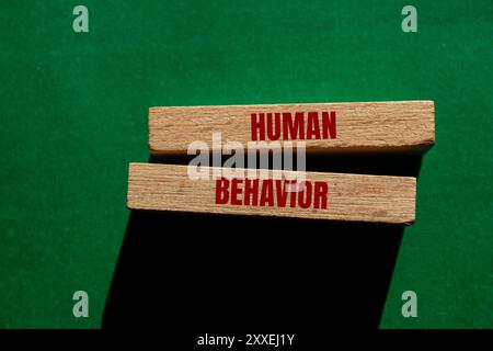 Human behavior message written on ripped torn yellow paper piece with ...