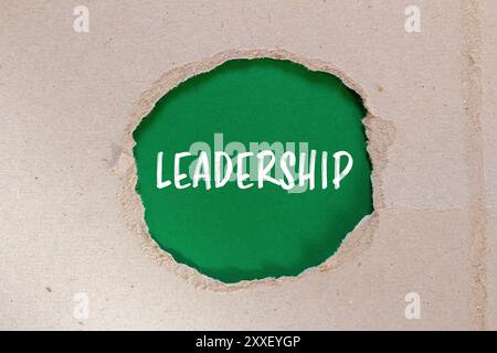 Leadership message written on ripped torn paper with green background ...