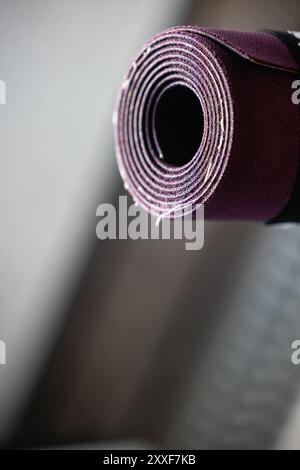 A yoga mat viewed from above, showing a rolled-up mat. Materials for ...