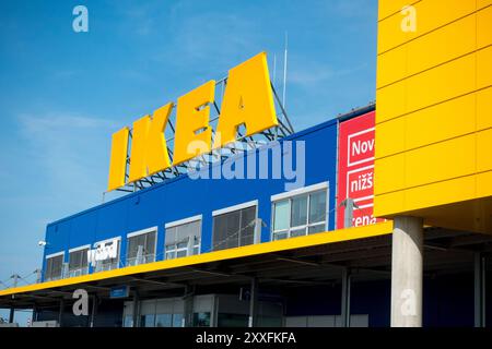 Sign Ikea logo against blue sky Man pushing cart Stock Photo - Alamy