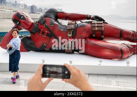 A visitor has his photo taken as he poses with the 8-meter installation ...