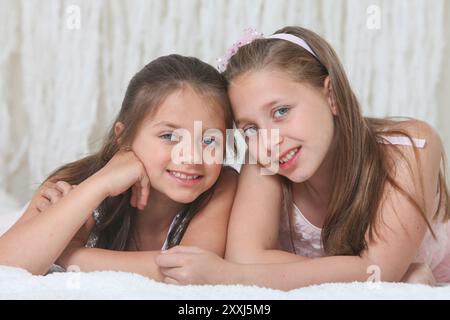 portrait of two pretty cheerful preteen girls in elegant dresses on ...