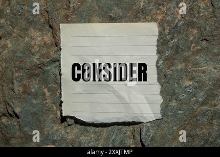 Consider message written on ripped torn paper piece with blue ...