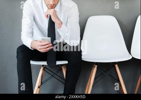 Staying in touch. Shot of an unrecognizable young businesswoman using ...