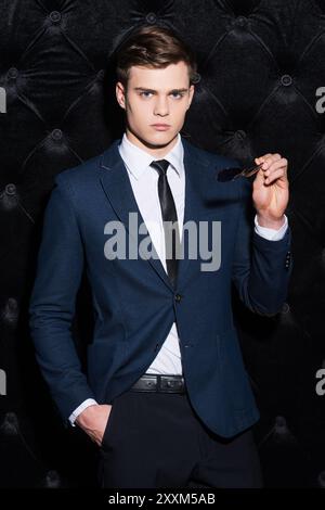 man with fashionable hairstyle holding the collar fashion self ...