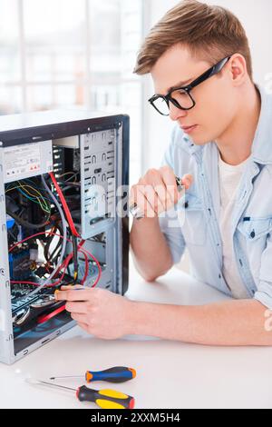 Young engineer repairing broken computer at the office Stock Photo - Alamy