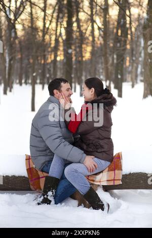 Couple at tree trunk smiling at each other Stock Photo - Alamy