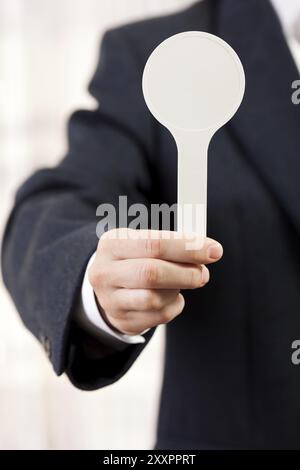 Human hand holding auction paddle voting card sign Stock Photo - Alamy