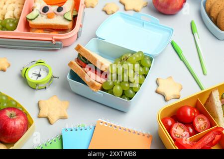 Lunch box with snacks, alarm clock and stationery on white table Stock ...