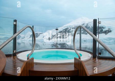 Hot tub with spa in winter with snow and decorated candles. Christmas ...