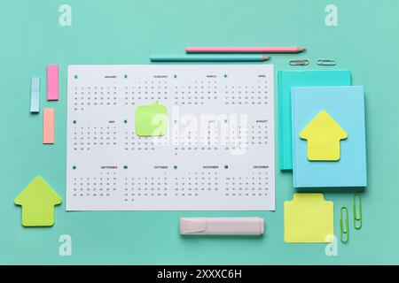 Calendar with office stationery on turquoise background Stock Photo - Alamy