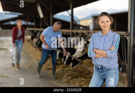 Cheerful woman posing in cowshed on farm breeding dairy cows Stock ...