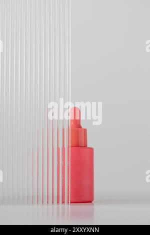 Vertical closeup shot of a dropper with red liquid over clean test ...