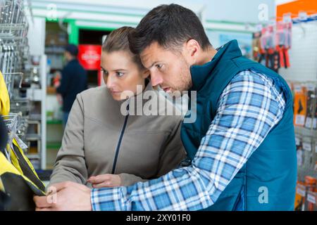 Couple purchasing tools for house improvements in paint supplies store ...