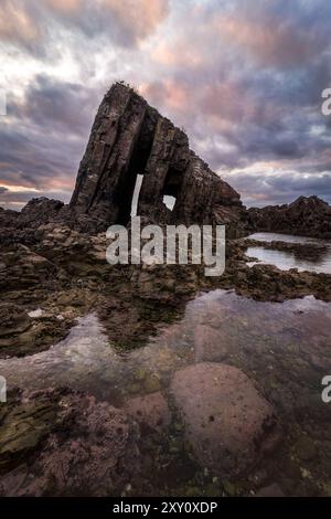 A striking rock formation, stands amidst the rugged desert landscape of ...