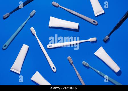 Tubes with toothpaste and toothbrushes on color background Stock Photo ...