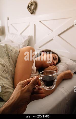 Morning routine. Awake man drink coffee using laptop. Morning in bed ...