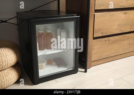 Mini refrigerator with different drinks and snacks indoors Stock Photo ...
