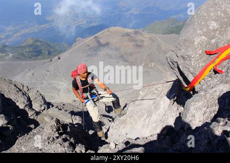 A climber descends lava rock on the peak wall of Merapi by using a ...