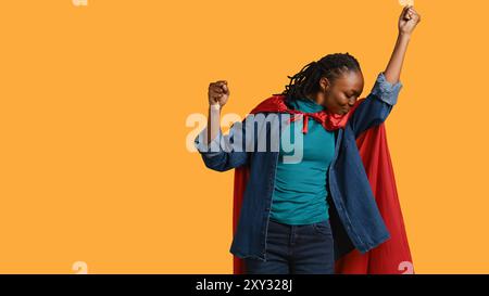 Happy superhero flexing muscles to prove force, listening music ...
