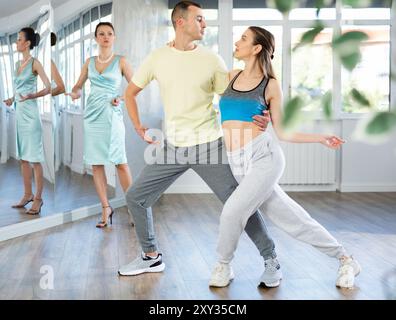 Couple practicing passionate tango guided by female dance instructor in ...