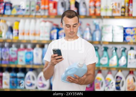 Man examines product liquid detergent in store Stock Photo - Alamy