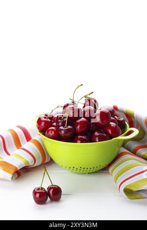 Colander with tasty ripe cherry on light background Stock Photo - Alamy