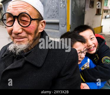 A Hui Muslim man with his grandchildren in Linxia, Gansu, China Stock ...