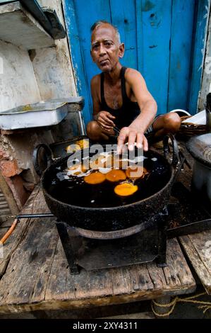 A man deep frying savory snacks on the street in Agra, India Stock ...