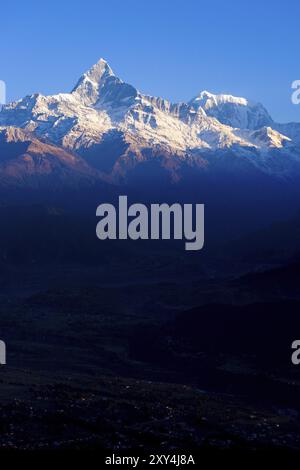 Alpine mountains covered with snow lighted up by the morning sunlight ...