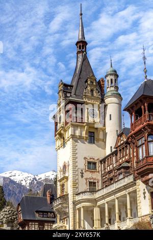 Peles castle tower close-up view and Carpathian mountains snow peaks ...